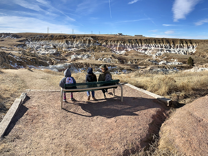 Three visitors share a moment of contemplation, proving that the best views are even better when savored with friends.