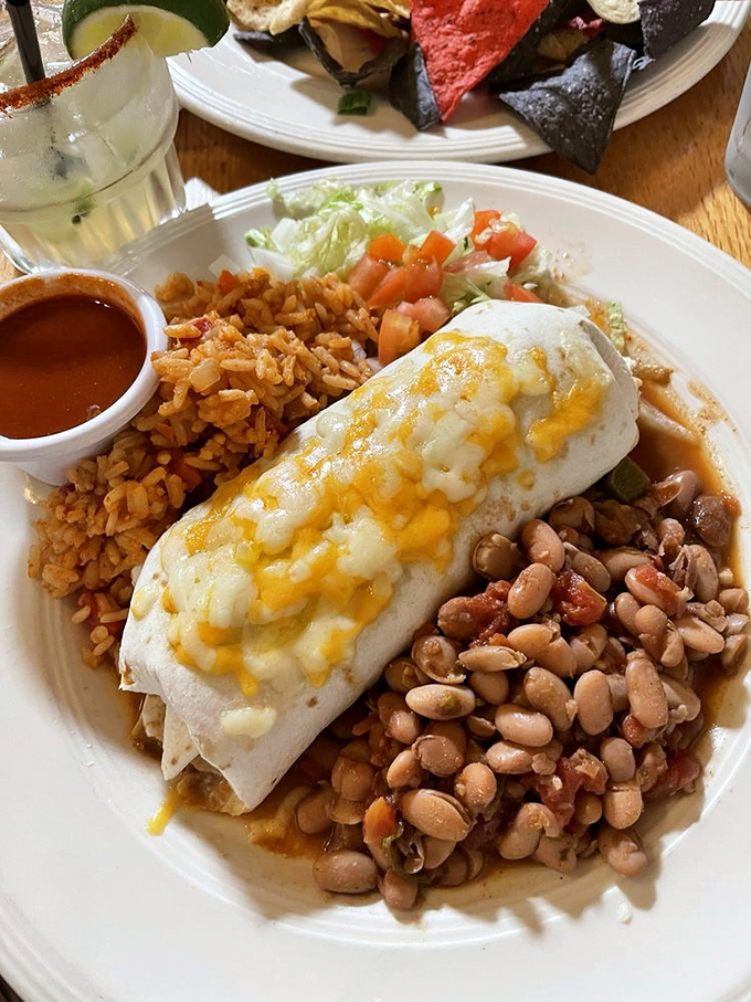 This burrito isn't just wrapped &ndash; it's embraced by melted cheese and surrounded by beans that have clearly been simmering to perfection.