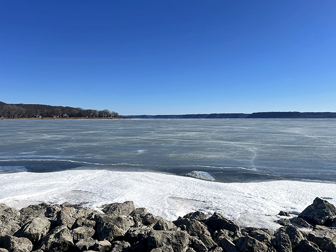 Lake Pepin in winter reveals its icy majesty. The frozen expanse stretches toward Minnesota shores, a breathtaking natural wonder.
