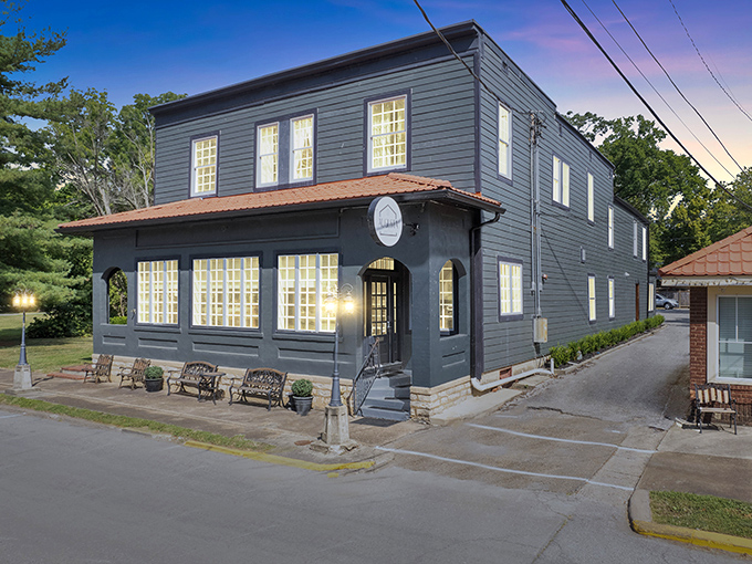The Benchmark Inn's elegant gray exterior and warm lighting invite weary travelers to experience Augusta's hospitality in sophisticated comfort.