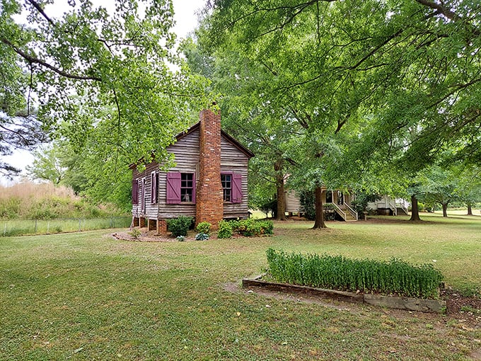 This historic cabin at Waynesborough Village whispers stories of simpler times, its weathered wood and brick chimney standing as testament to the area's rich agricultural heritage.