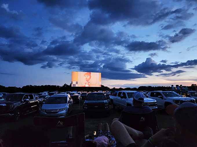 The drive-in's evening glow begins as families settle in with lawn chairs and comfort food. Dinner and a movie, Alabama-style.