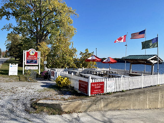 The perfect lakeside welcome. White picket fences, colorful umbrellas, and three flags fluttering in the breeze&mdash;Norman Rockwell couldn't have painted it better.