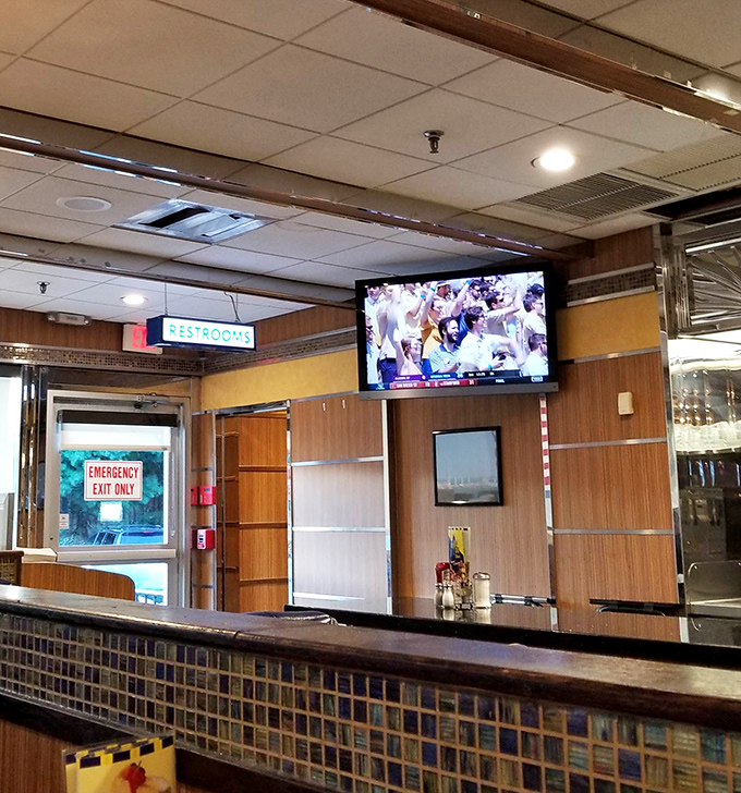 Even the path to the restrooms has that classic diner aesthetic&mdash;wood paneling and a TV, because missing the game is never on the menu.