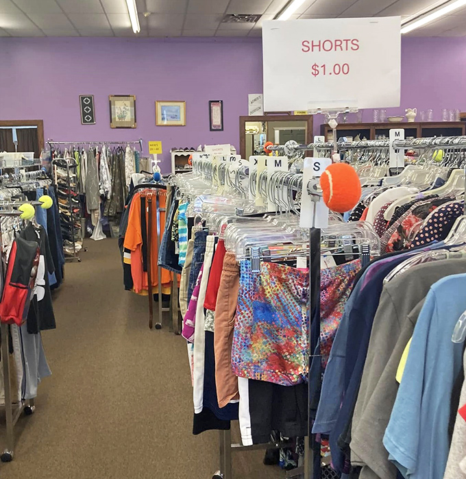 Clothing racks organized by size create colorful pathways through the store, with helpful signs guiding shoppers to dollar-priced shorts.