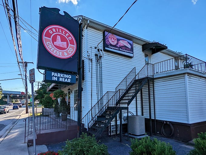 The side view reveals stairs leading to grilled cheese paradise. That red sign is like a beacon for comfort food seekers.