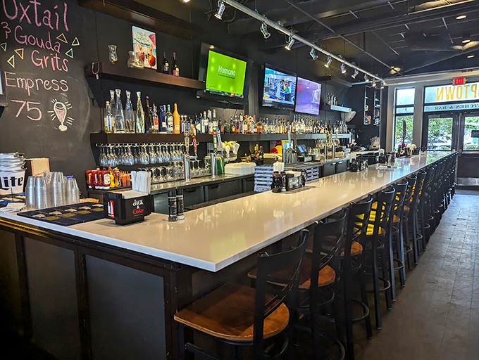 The expansive bar invites conversation with its gleaming white countertop and impressive array of spirits. A mixologist's playground and a drinker's delight.