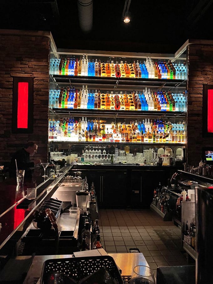 The bar at Firebirds isn't just stocked&mdash;it's a backlit masterpiece of bottles arranged like a liquid library. A rainbow of spirits awaiting their moment.