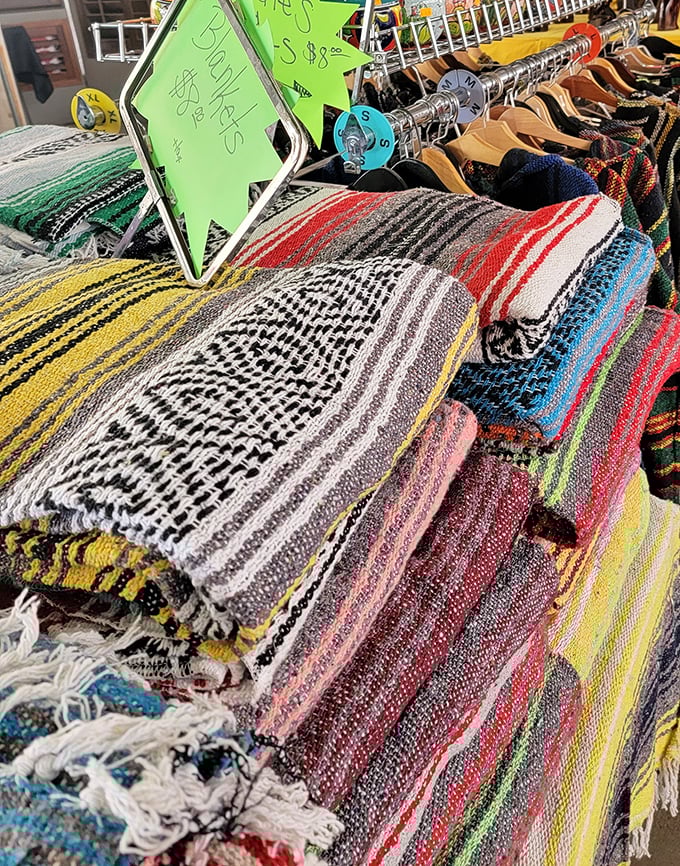 Mexican blankets lined up like a textile rainbow, each promising to be the perfect picnic companion or emergency fashion statement.