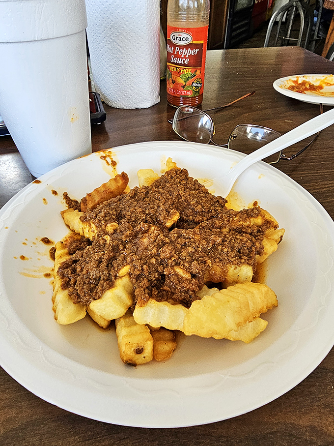 Crinkle fries buried under a generous blanket of chili become a fork-requiring meal that defies all hot dog logic.