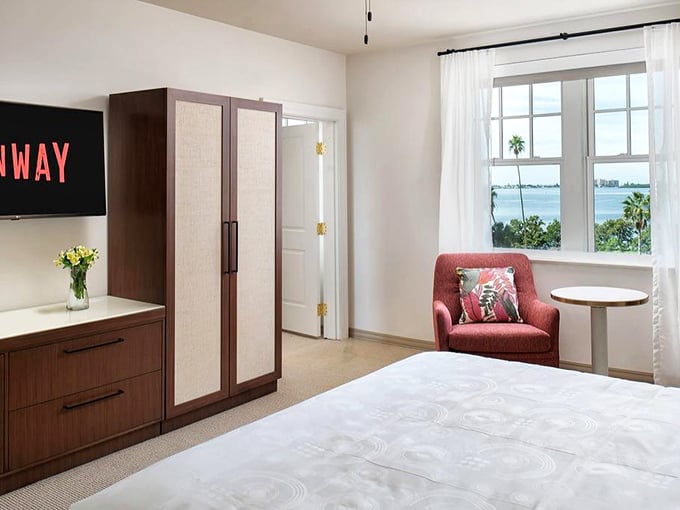 The Fenway Hotel room offers waterfront views and vintage elegance that whispers "Jazz Age glamour lives here."