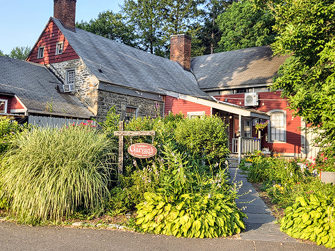 Garvan's Gastropub emerges from lush gardens like a storybook cottage, promising culinary delights behind its historic stone walls.