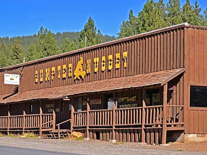 The Sumpter Nugget's rustic wooden facade and welcoming porch invite visitors to rest their boots after a day of mountain exploration.