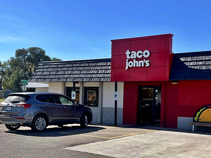Taco John's bright red sign beckons hungry travelers, a familiar comfort in the vast prairie landscape.