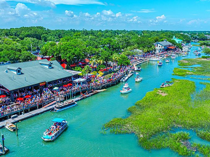 The MarshWalk buzzes with festival energy as boats cruise by and crowds gather for good times and great food.