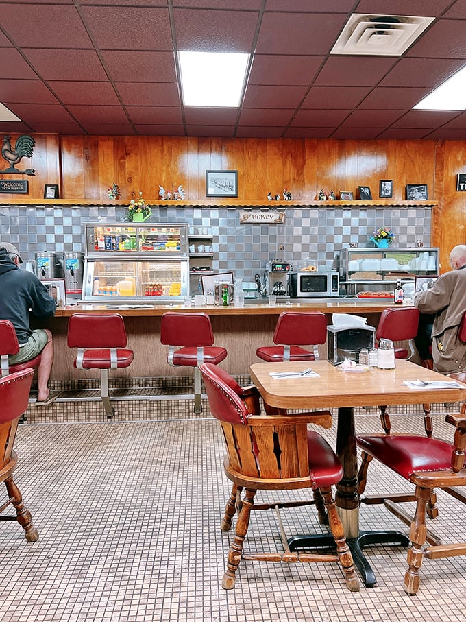 The counter where magic happens &ndash; red vinyl stools, wood paneling, and blue tile backsplash creating the perfect backdrop for breakfast dreams.