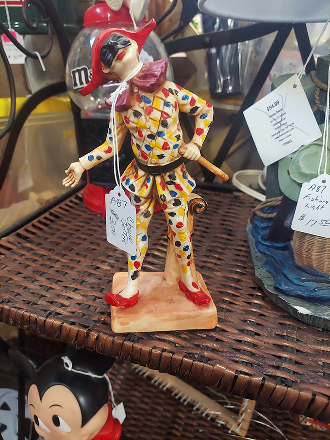 A jaunty harlequin figurine strikes a pose, his colorful costume a splash of whimsy among the treasures. Someone's curio cabinet is calling.