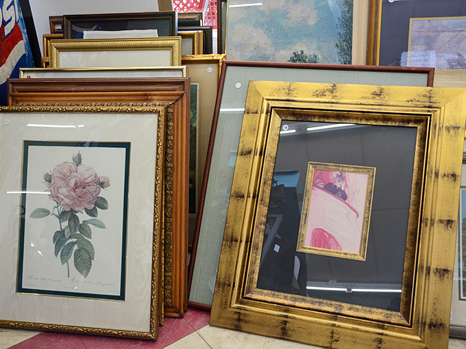 Framed artwork leans casually against the wall, including botanical prints that would look perfectly at home in a British period drama.