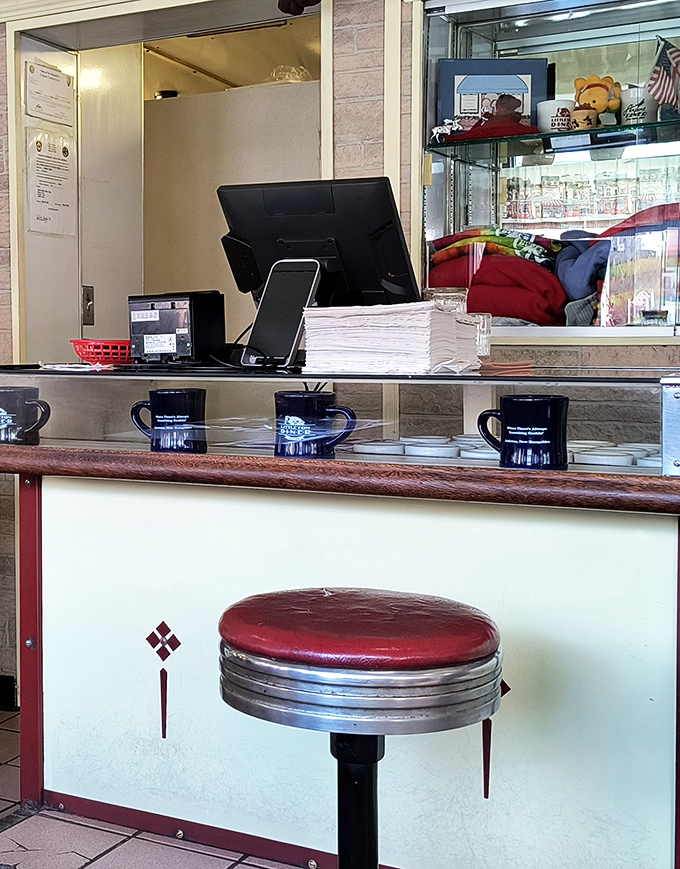 The order counter sits ready with coffee mugs lined up like soldiers, prepared to caffeinate the morning rush with efficiency and friendliness.
