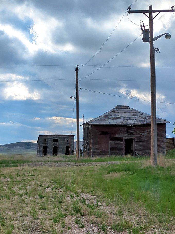 Power lines stretch toward distant horizons past abandoned buildings, connecting Scenic's quiet present to a world that moved on without it.
