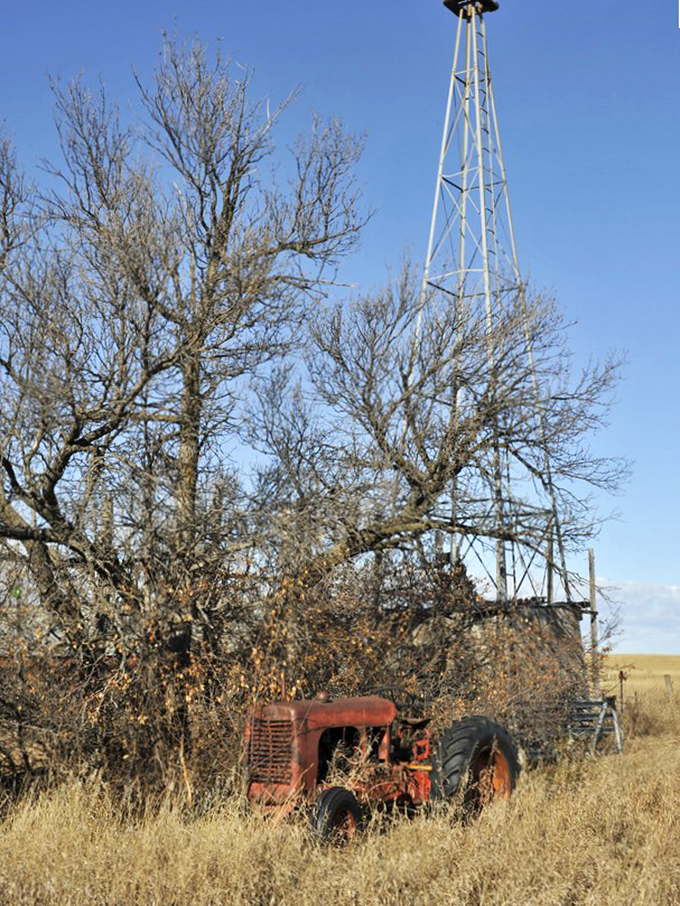 A rusted tractor, once the pride of a hardworking farmer, now serves as an unintentional monument to prairie perseverance.
