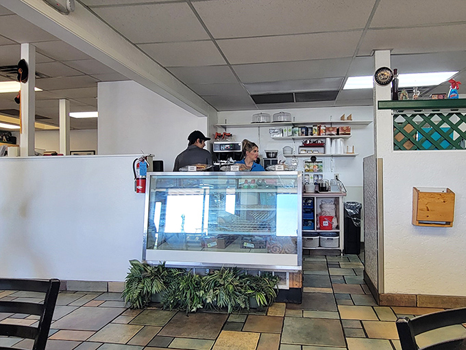 The display case and counter area—where dessert decisions are made, coffee is poured, and friendly staff keep the whole operation humming.