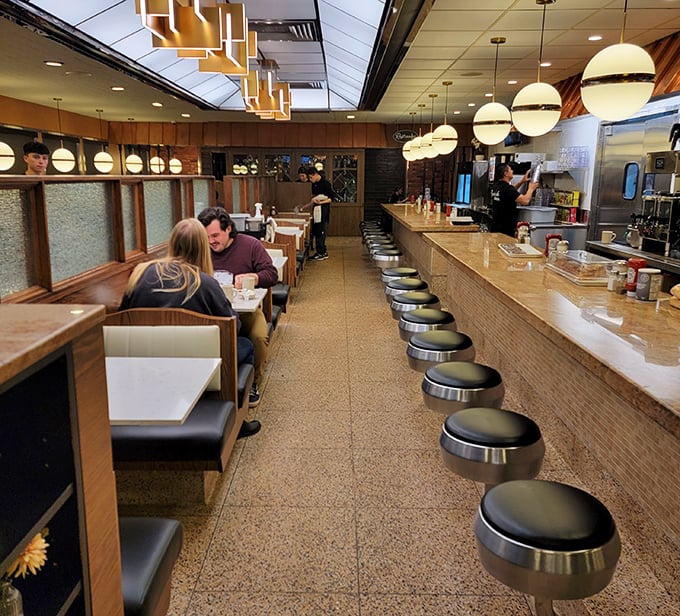 Classic diner seating with modern lighting creates the perfect backdrop for everything from first dates to family celebrations.