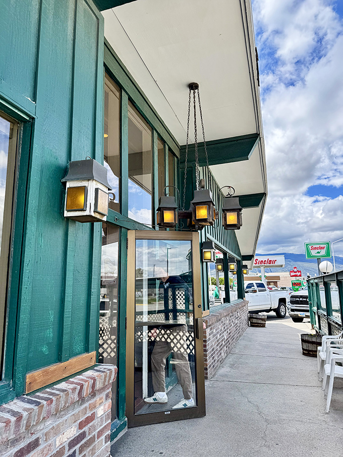 Rustic lanterns guide you to the entrance like friendly sentinels. The green trim says "welcome" in a language every hungry traveler understands.