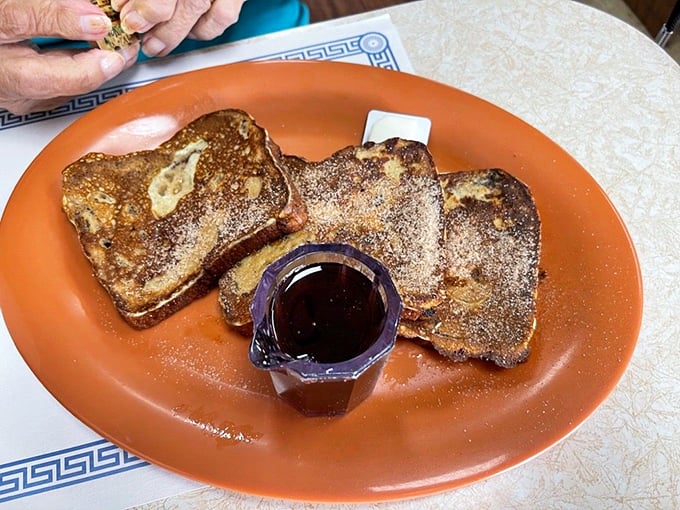 French toast that's achieved the perfect golden-brown complexion. That tiny pitcher of syrup is about to make someone very happy.