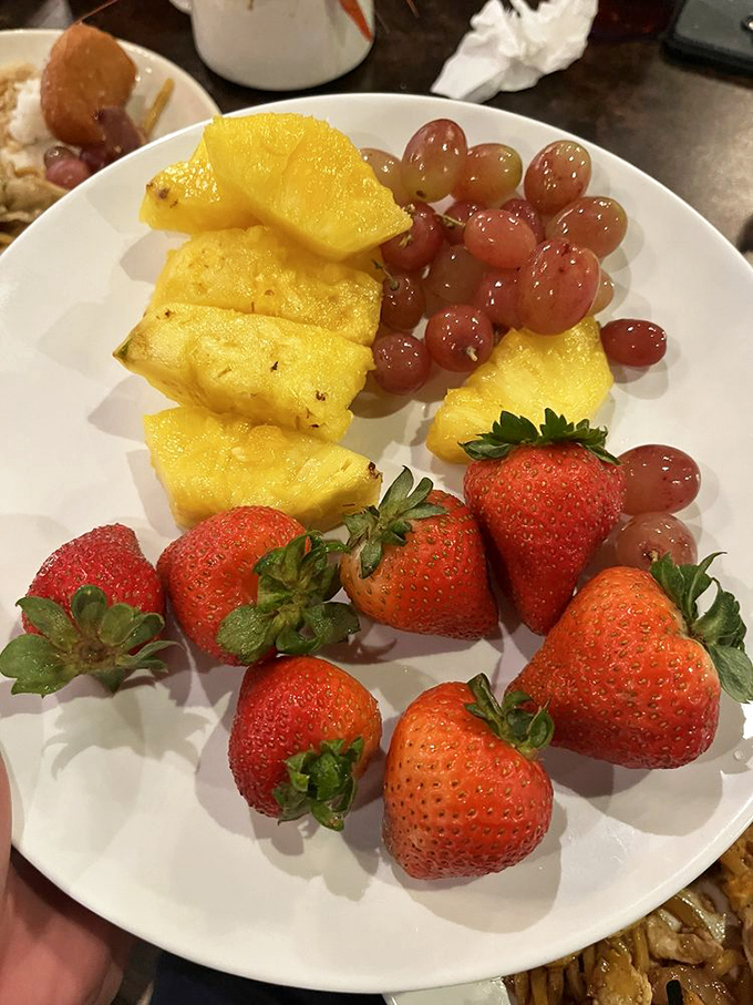 Nature's dessert: a plate of vibrant strawberries, pineapple, and grapes that offers a refreshing intermission between buffet adventures.
