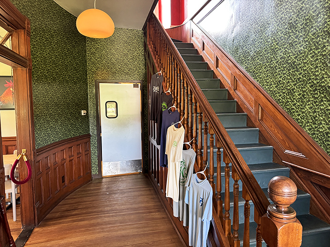 The entrance hallway's green wallpaper and wooden staircase create the perfect backdrop for Hooper's merchandise &ndash; wear the t-shirt to prove you survived the experience!