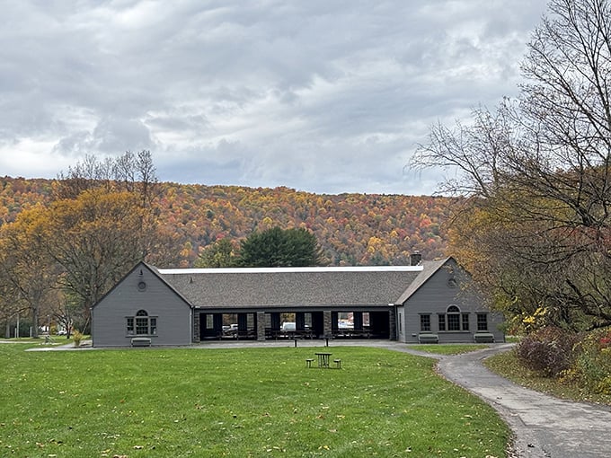 The park's visitor center stands ready to welcome explorers, backed by hills ablaze with autumn's fiery fashion statement.