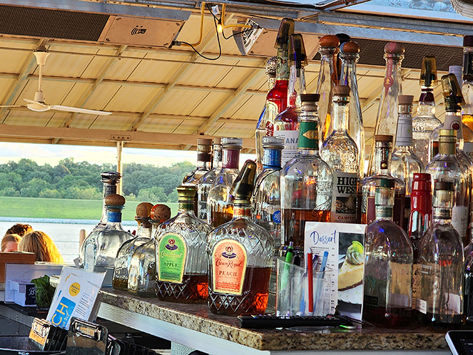A bar stocked for serious business with the reservoir as its backdrop. These bottles aren't just alcohol&mdash;they're potential memories waiting to be poured.