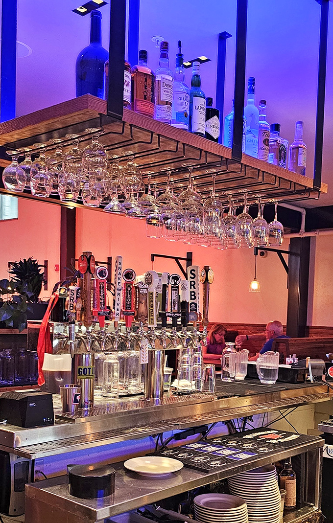 The bar's suspended glassware catches the blue light like crystal icicles - a fitting Wyoming touch to an impressive spirits selection.