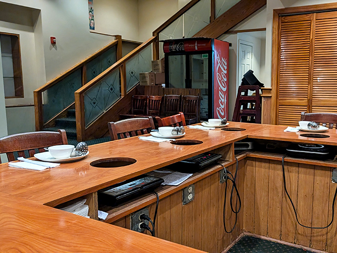 These built-in cooking stations transform diners into chefs. The circular openings await their hot pot vessels like empty stages before a performance.