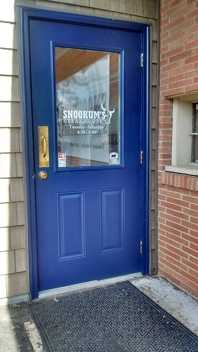 The blue door stands like a portal to meat paradise, with hours clearly posted for those planning their carnivorous pilgrimages.