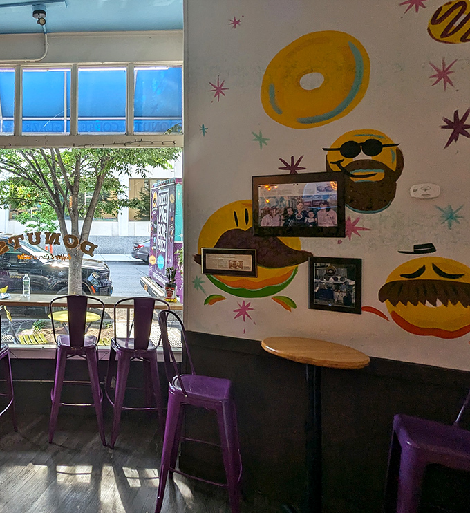 Whimsical donut characters with sunglasses and mustaches watch over diners from walls painted with starbursts and sprinkles.