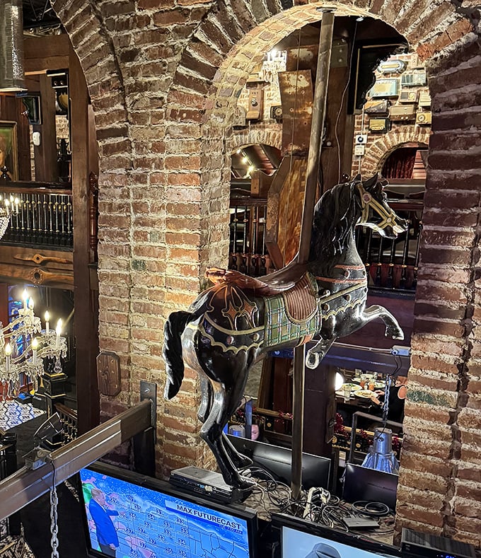 A carousel horse suspended in mid-gallop, because why not add a touch of whimsy to your dining experience? The brick archways frame the unexpected perfectly.