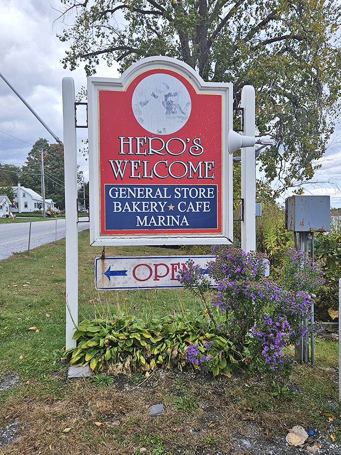 A sign that delivers on its promises. The purple asters below seem to nod in agreement that yes, heroes are indeed welcome here.