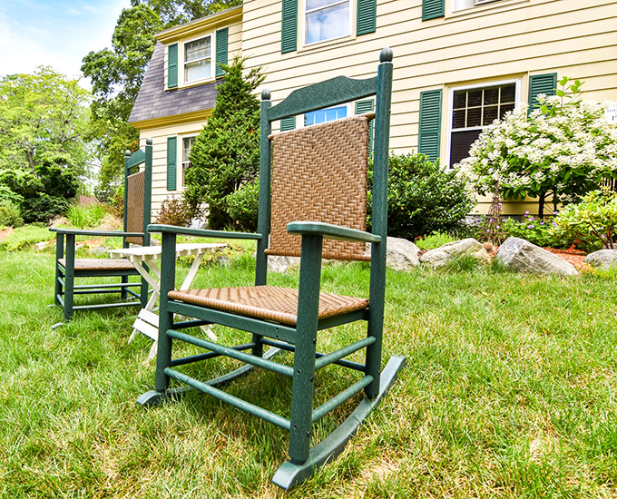 These green rocking chairs on the lawn aren't just furniture—they're an invitation to slow down and remember what vacation actually means.