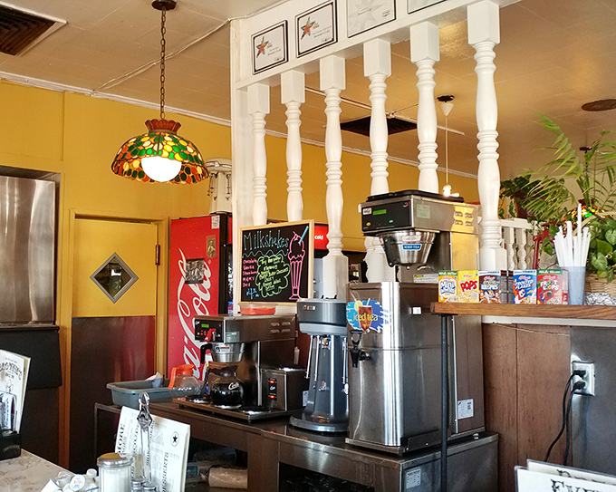 Coffee station with vintage Tiffany-style lamps overhead&mdash;because even utilitarian spaces deserve a touch of beauty.