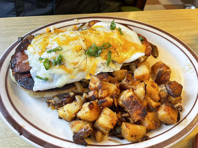 A sunny-side-up egg crowns this hearty breakfast like a golden halo, while those home fries huddle nearby, crispy and ready for their close-up.