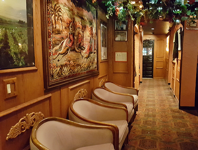 The hallway's elegant seating and ornate tapestries create a waiting area that feels less like a restaurant queue and more like the antechamber to a flavor palace.