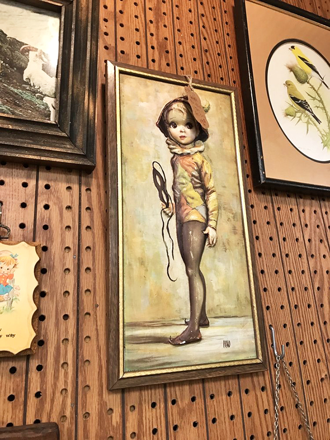 The "big-eyed waif" painting that somehow manages to be both charming and slightly unsettling. Mid-century art that follows you across the room.