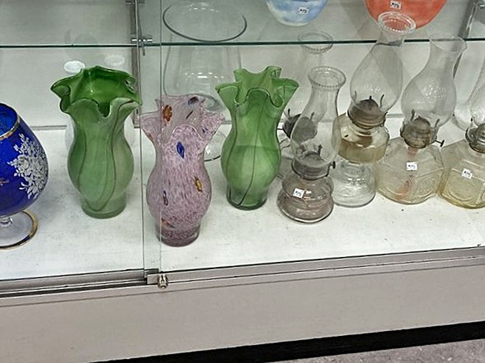 Vintage glassware gallery showcasing yesterday's elegance. Those green ruffled vases would make even supermarket flowers look like a million bucks.
