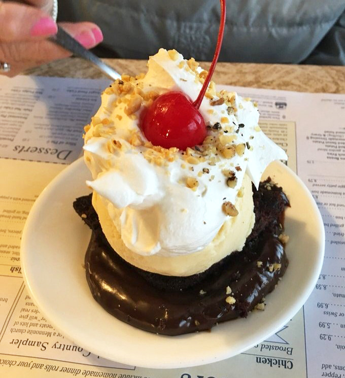 Hot fudge cake topped with ice cream and a cherry, proving that chocolate therapy is real and delicious.
