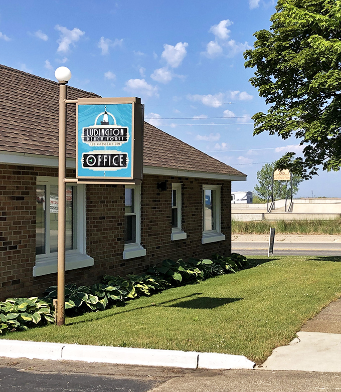 The Ludington Beach House sign promises lakeside accommodations where the sound of waves replaces your alarm clock. Best upgrade ever.