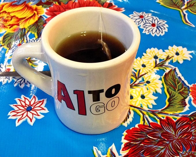 A humble mug of tea on a vibrant oilcloth. Sometimes the simplest pleasures &ndash; like the A1's branded mug &ndash; create the most lasting memories.