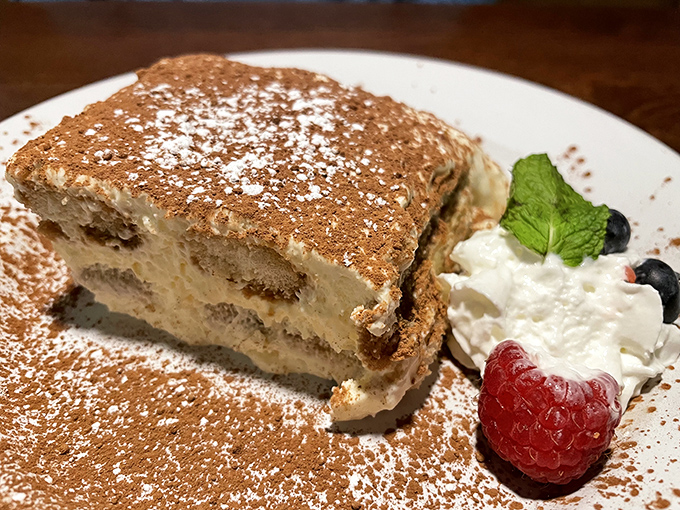 Tiramisu that doesn't just end the meal, it provides closure with a dusting of cocoa and a side of fresh berries for good measure.