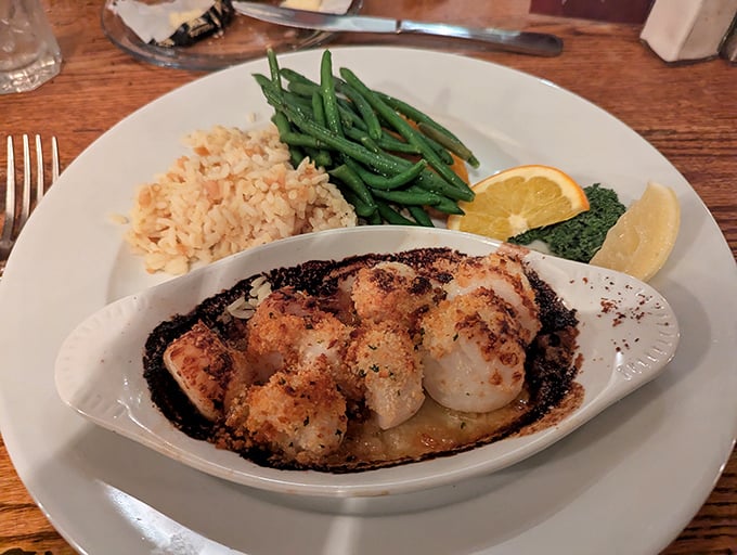 Broiled scallops, caramelized to perfection, nestled in their own dish alongside colorful vegetables&mdash;proof that sometimes the simplest preparation yields the most profound flavors.